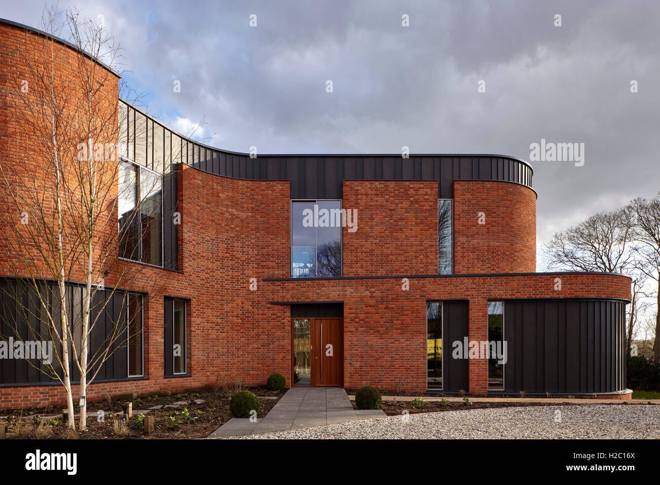 Detail of Front elevation with entrance and large curved brick facade ...