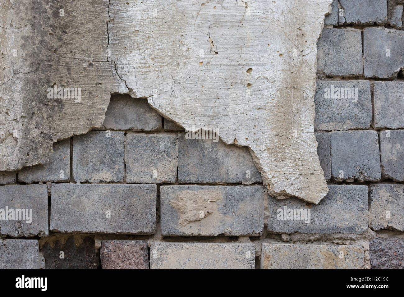 the broken plaster on the wall of the blocks Stock Photo - Alamy