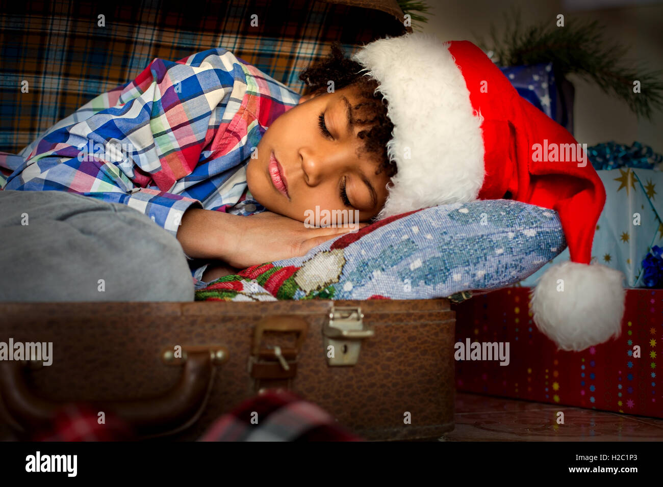 Boy's Christmas nap beside presents Stock Photo - Alamy