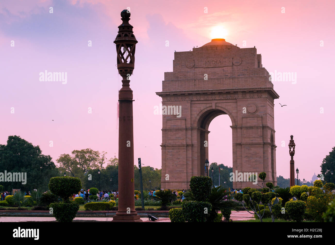 India gate in Delhi shot at dusk with the sun overhead and with a ...