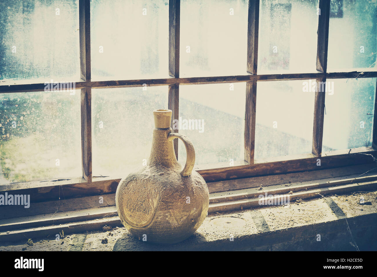 Retro filtered an old dusty clay bottle by a window Stock Photo - Alamy