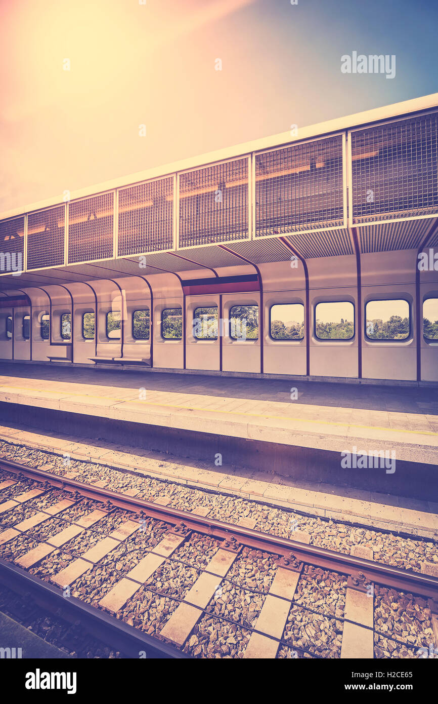 Vintage toned empty railroad station seen from train at sunset, travel ...