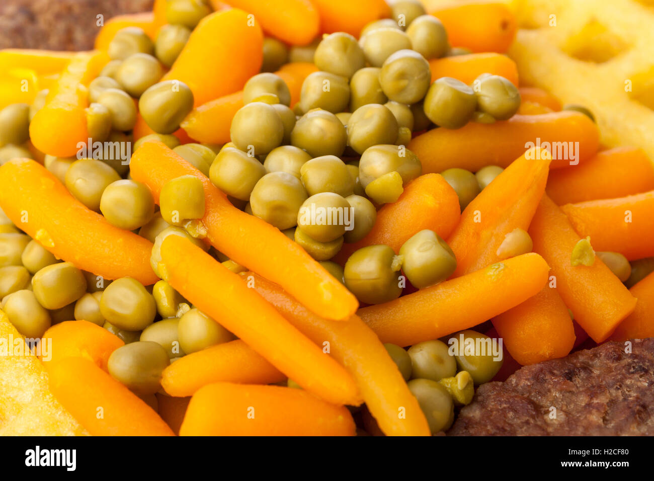 Close up shot of peas and carrots with burgers and potato waffles Stock ...