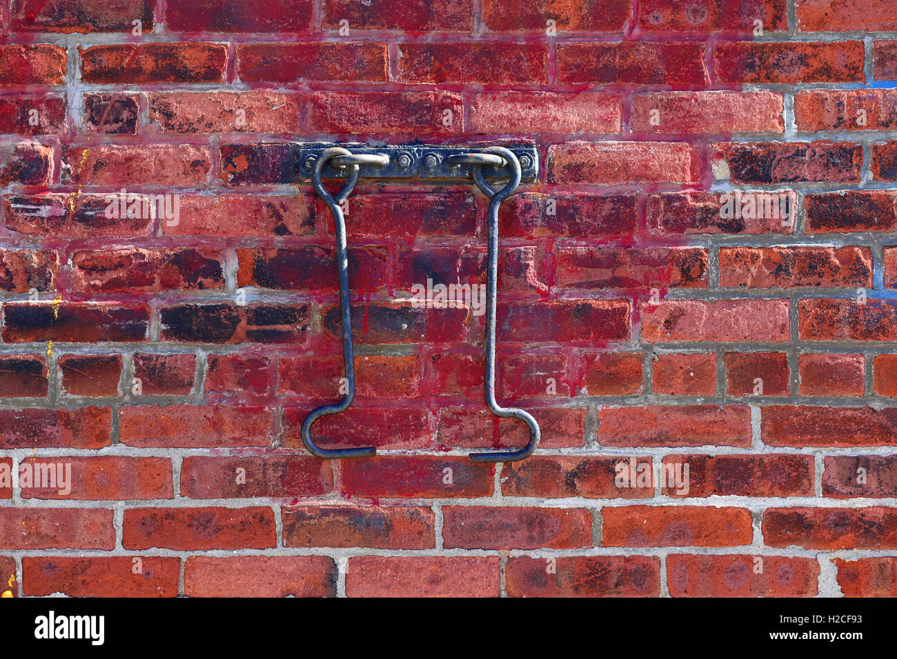 Two hooks on a red brick wall Stock Photo - Alamy