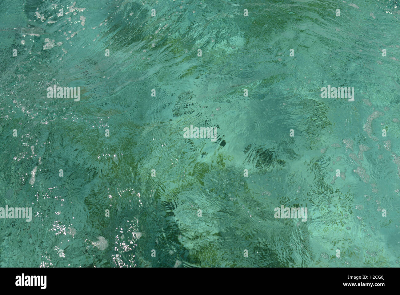 Clear turquoise ocean water with shadows of coral showing through Stock ...