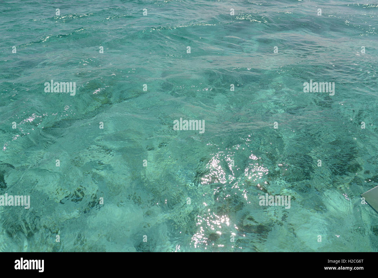 Clear turquoise ocean water with shadows of coral showing through Stock ...