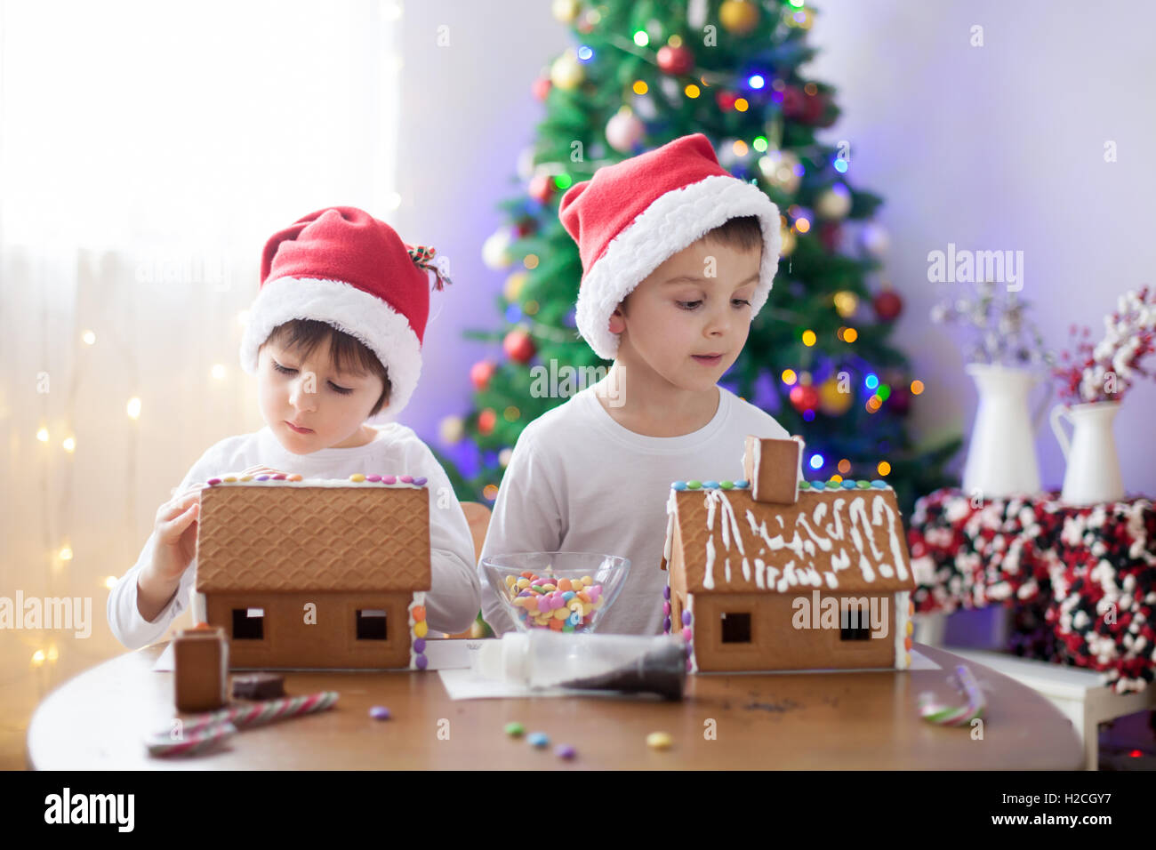 Two sweet boys, brothers, making gingerbread cookies house, decorating ...