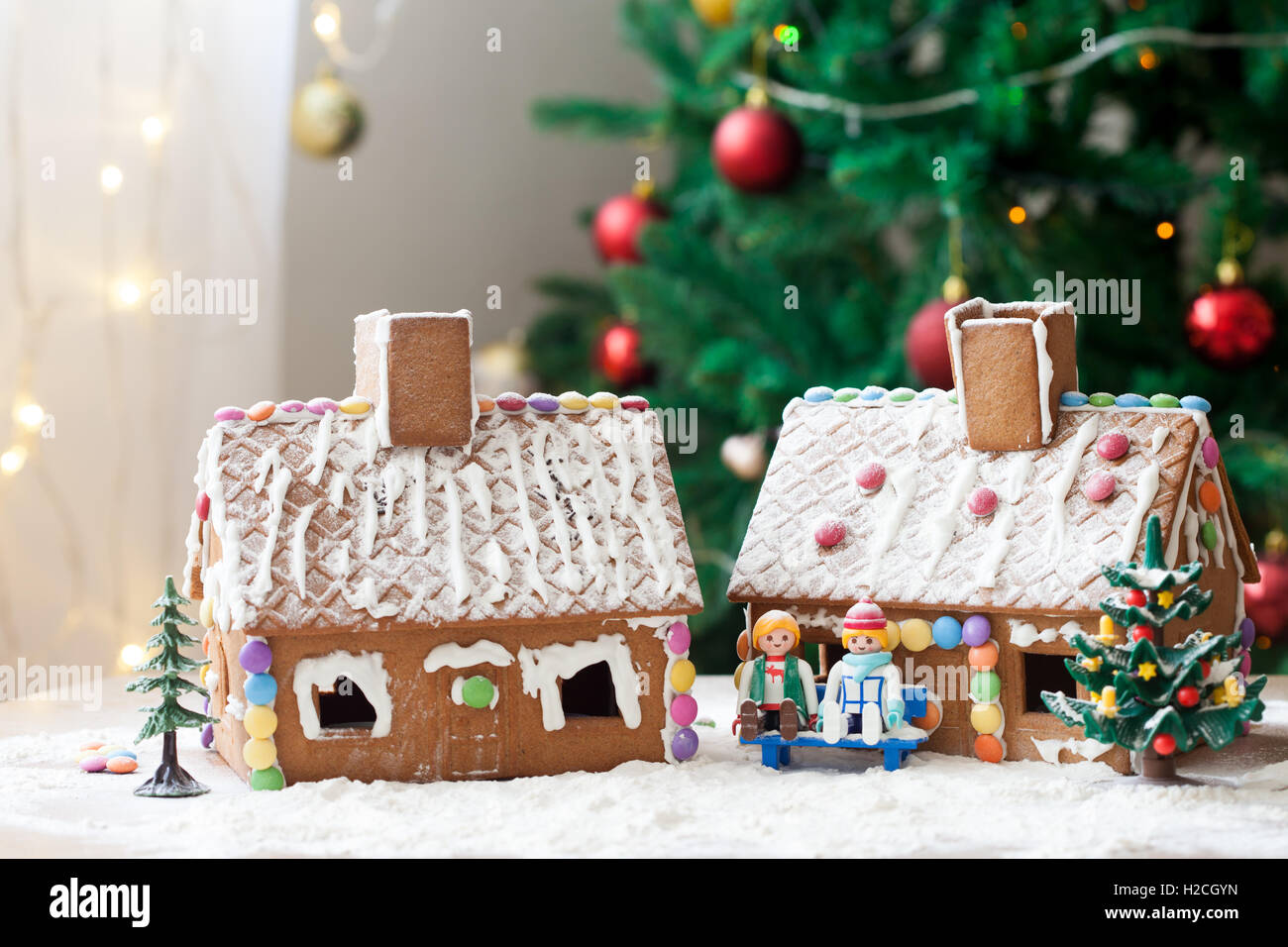 Two gingerbread houses, tree and people sitting on a bench, winter ...