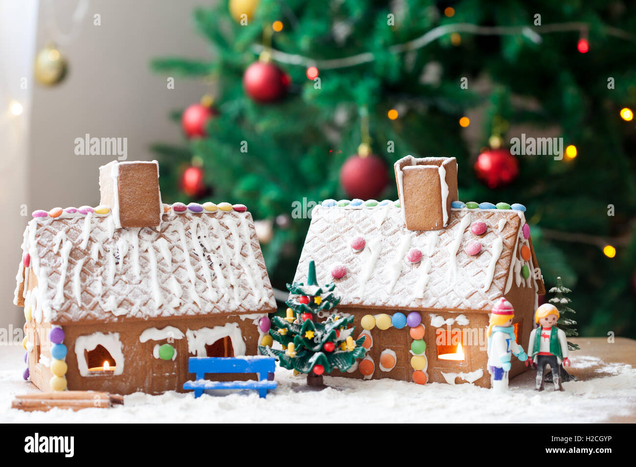 Two gingerbread houses, tree and people sitting on a bench, winter ...