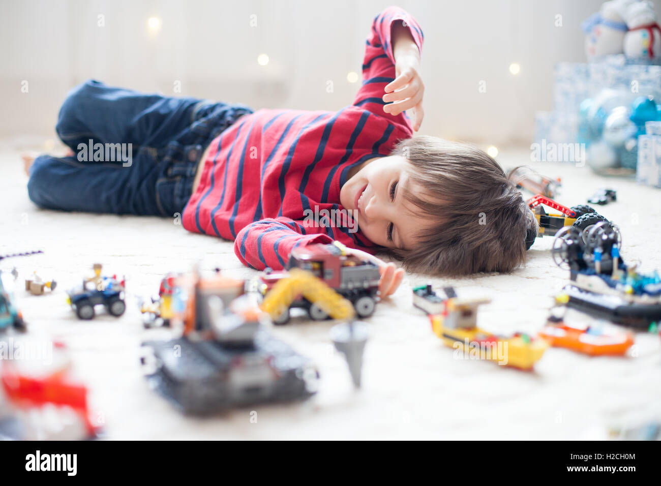 Little child playing with lots of colorful plastic toys indoor ...