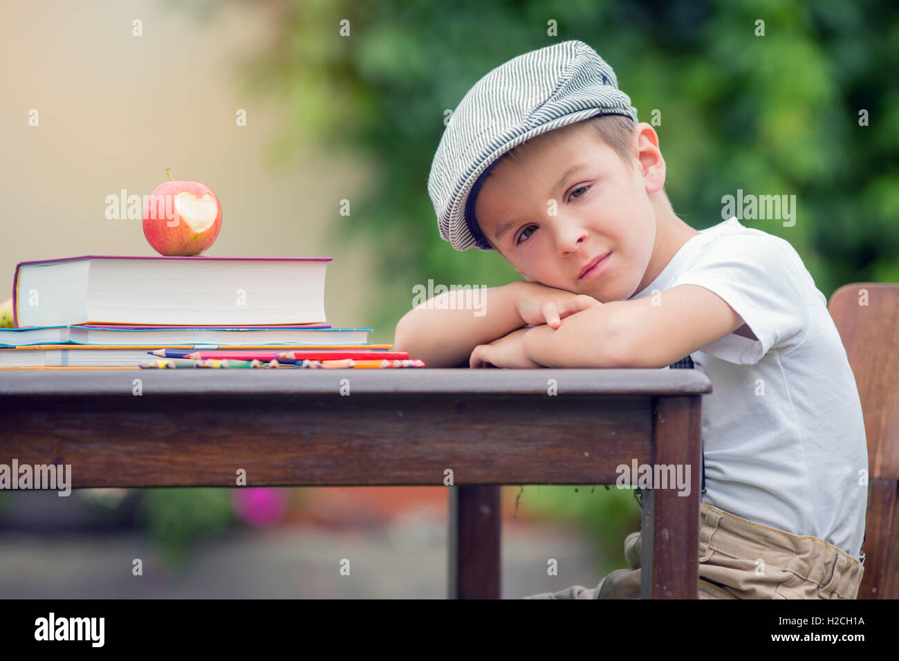 Boy, writing his homework from school, drawing and writing in his ...