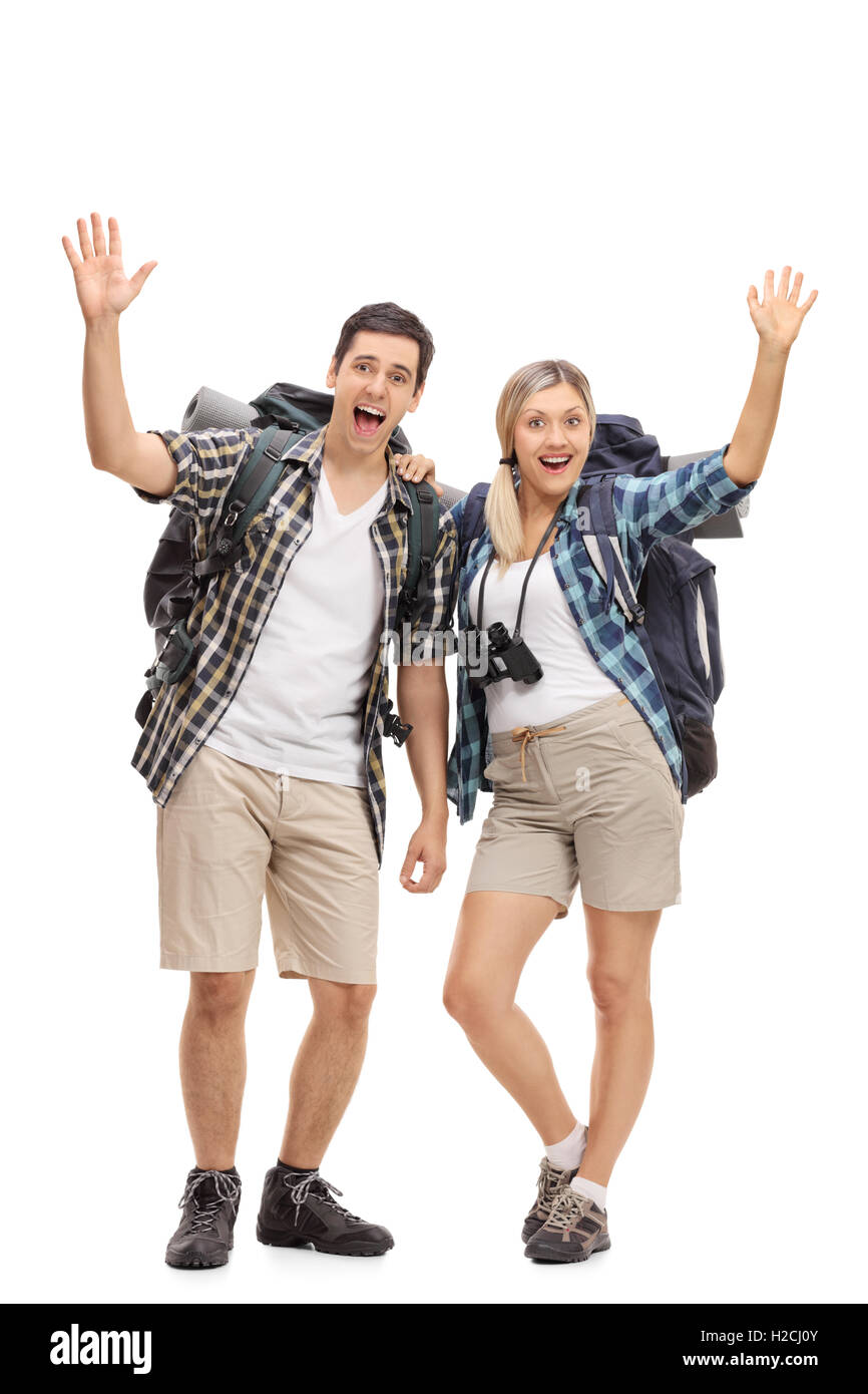 Full length portrait of two happy hikers waving at the camera isolated ...