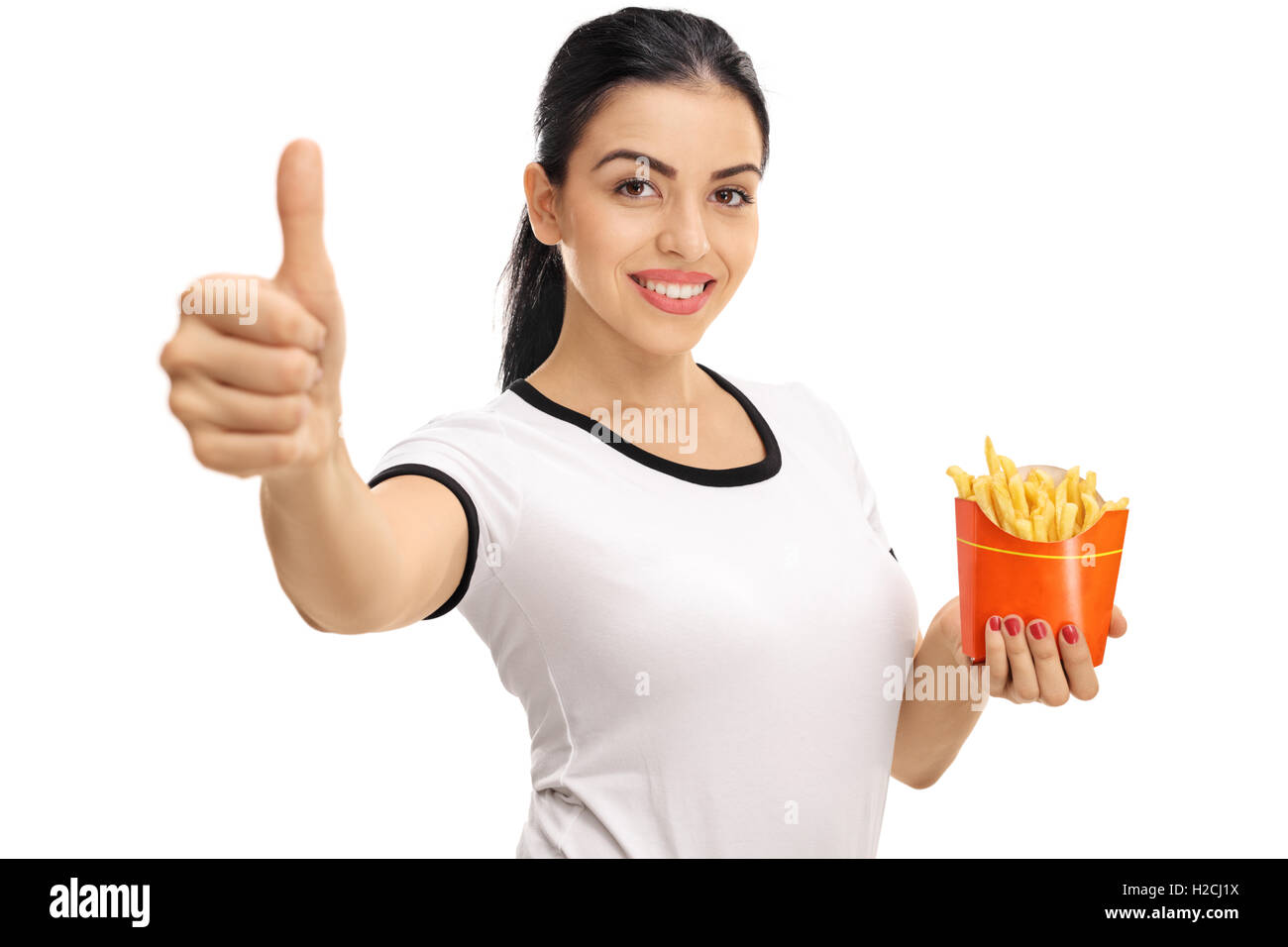 Smiling woman holding a bag of fries and giving a thumb up isolated on ...
