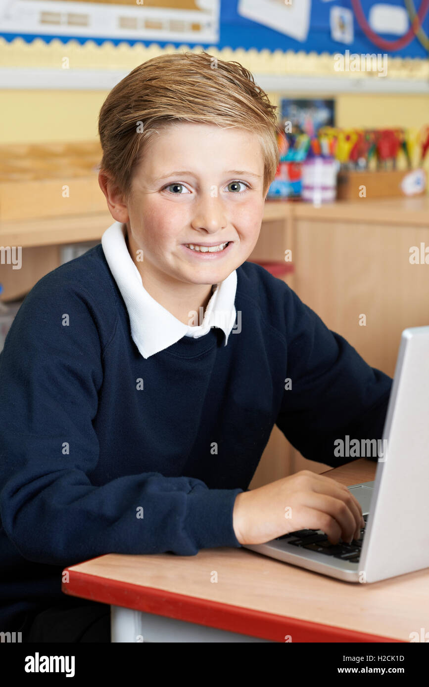 Male Elementary School Pupil Using Laptop In Computer Class Stock Photo ...