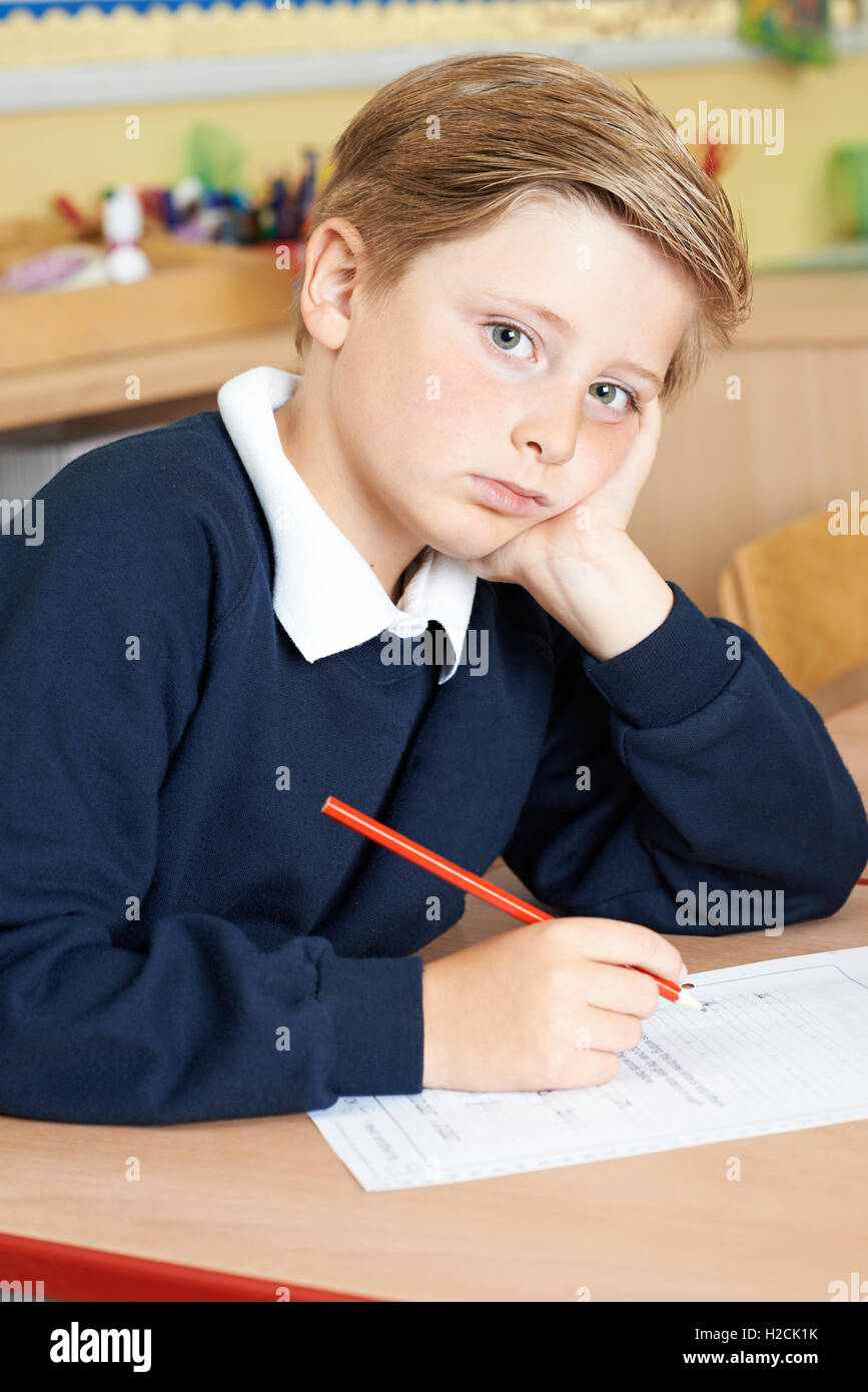 Bored Male Elementary School Pupil At Desk Stock Photo - Alamy