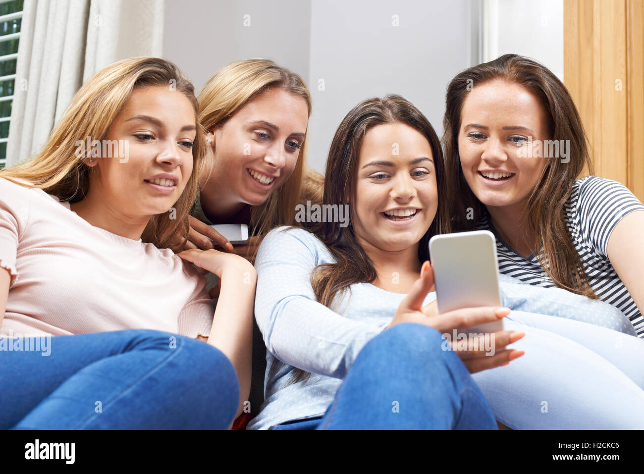 Group Of Teenage Girls Reading Text Message On Mobile Phone Stock Photo ...