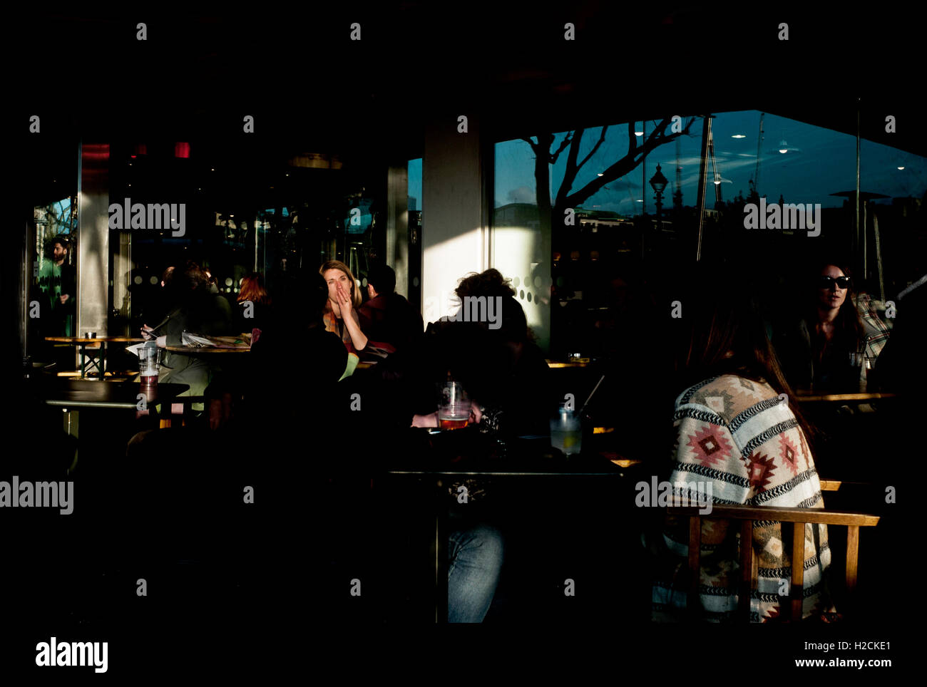 sun lit face stands out from the crowd in a shadowy bar south bank ...