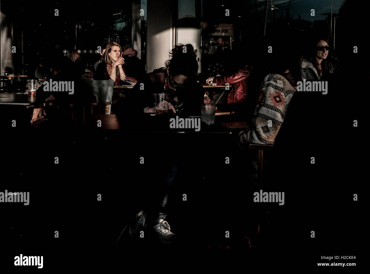 sun lit face stands out from the crowd in a shadowy bar south bank ...