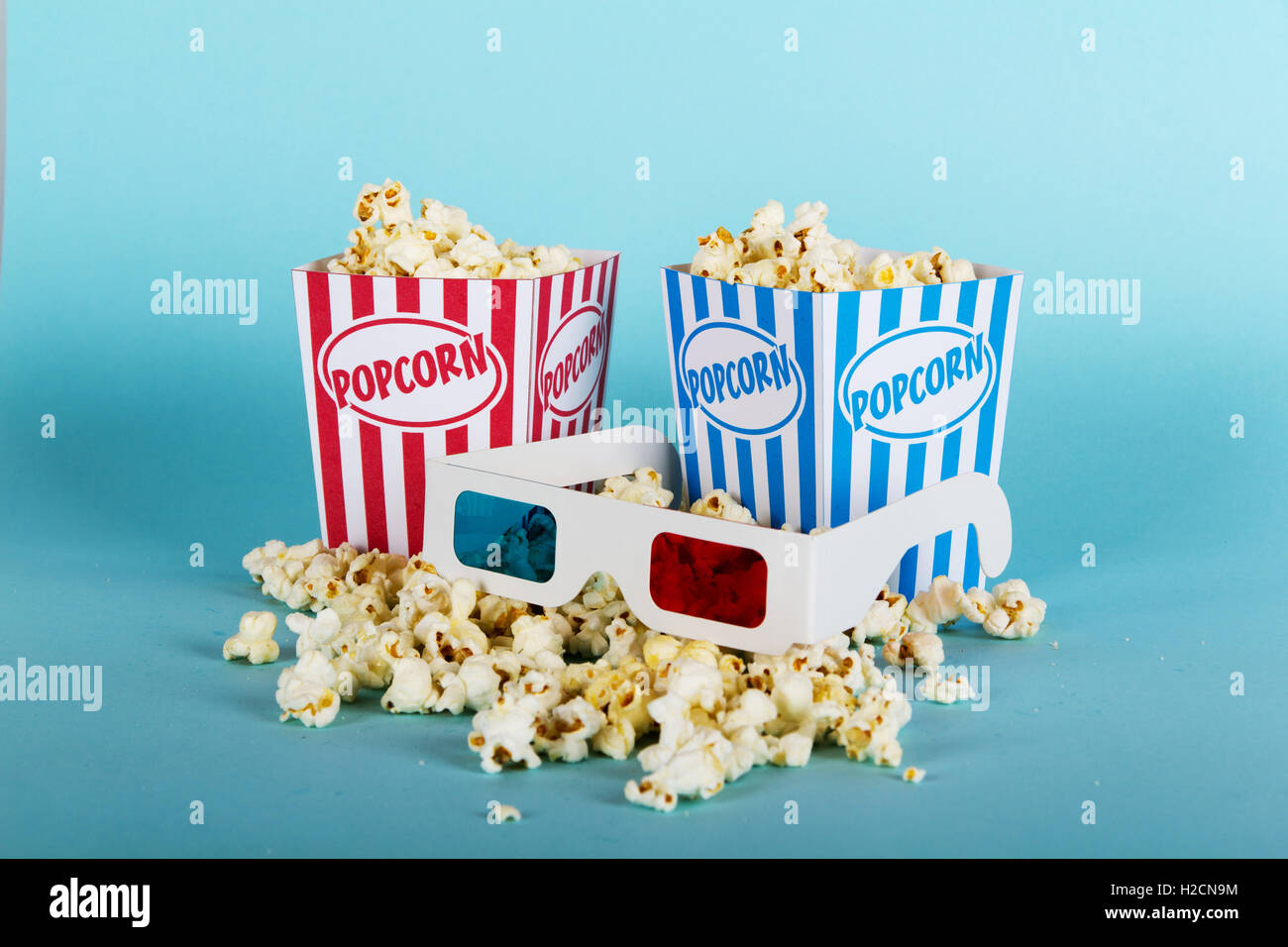 Bucket of popcorn against a blue background Stock Photo - Alamy