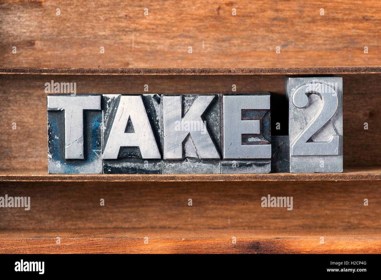 take two phrase made from metallic letterpress type on wooden tray ...