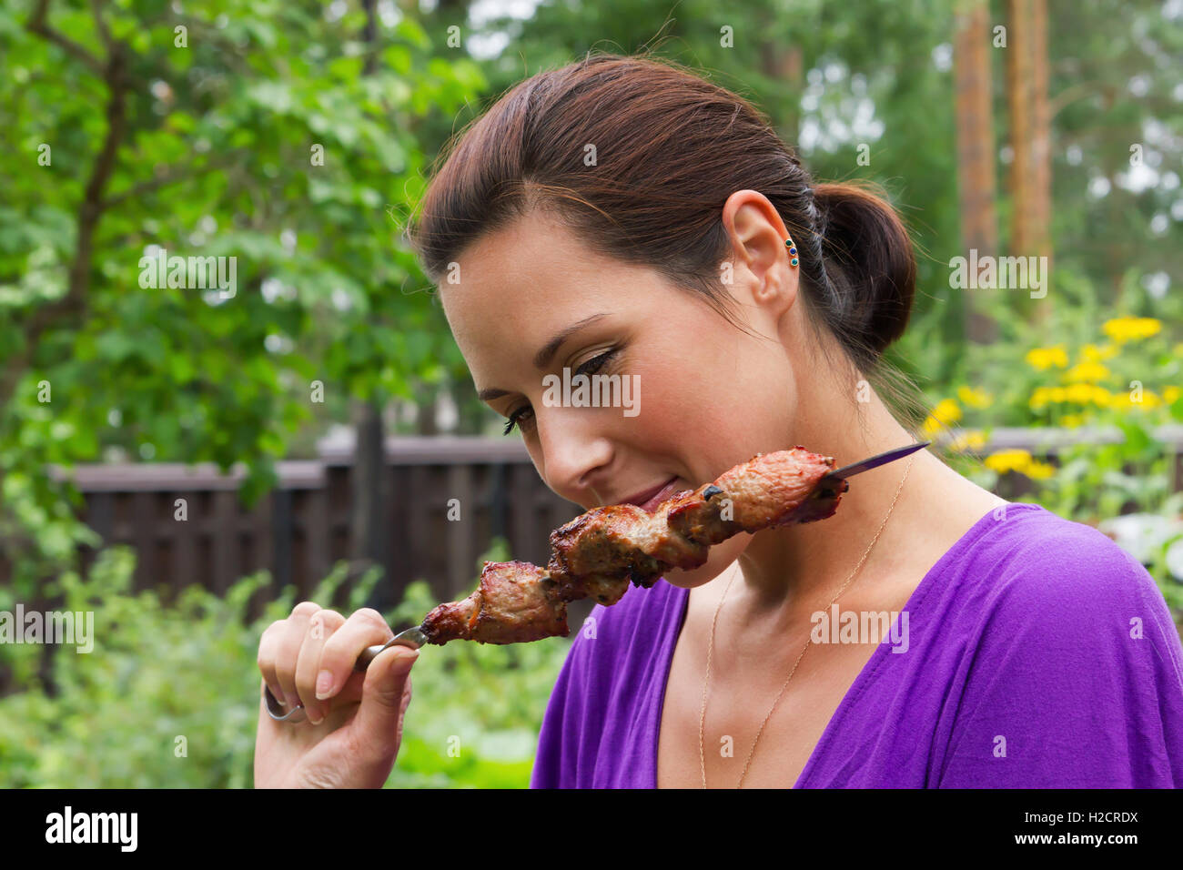 Pretty woman enjoying barbecue outdoors Stock Photo - Alamy