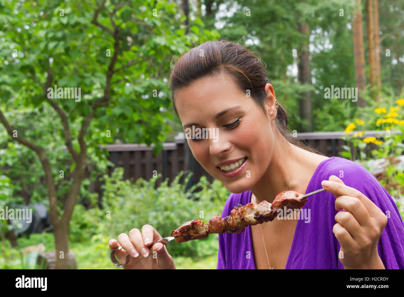 Pretty woman enjoying barbecue outdoors Stock Photo - Alamy