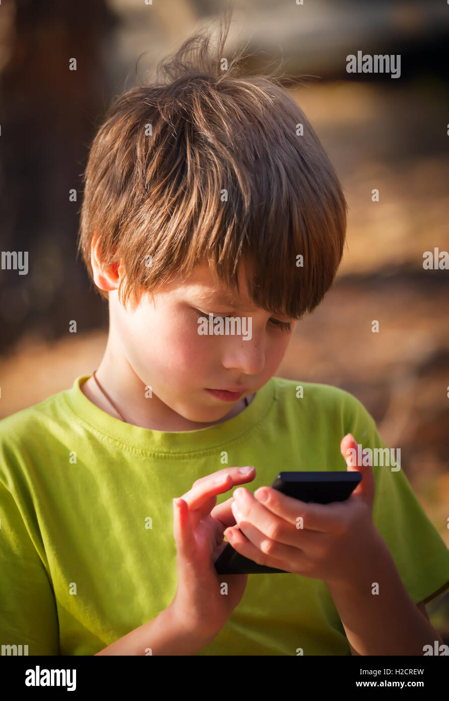 Child playing mobile phone outdoors little boy Stock Photo - Alamy