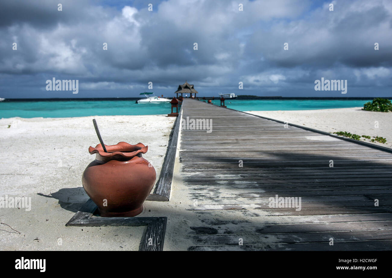 A water jar for washing feet at the boardwalk to a jetty on an island ...