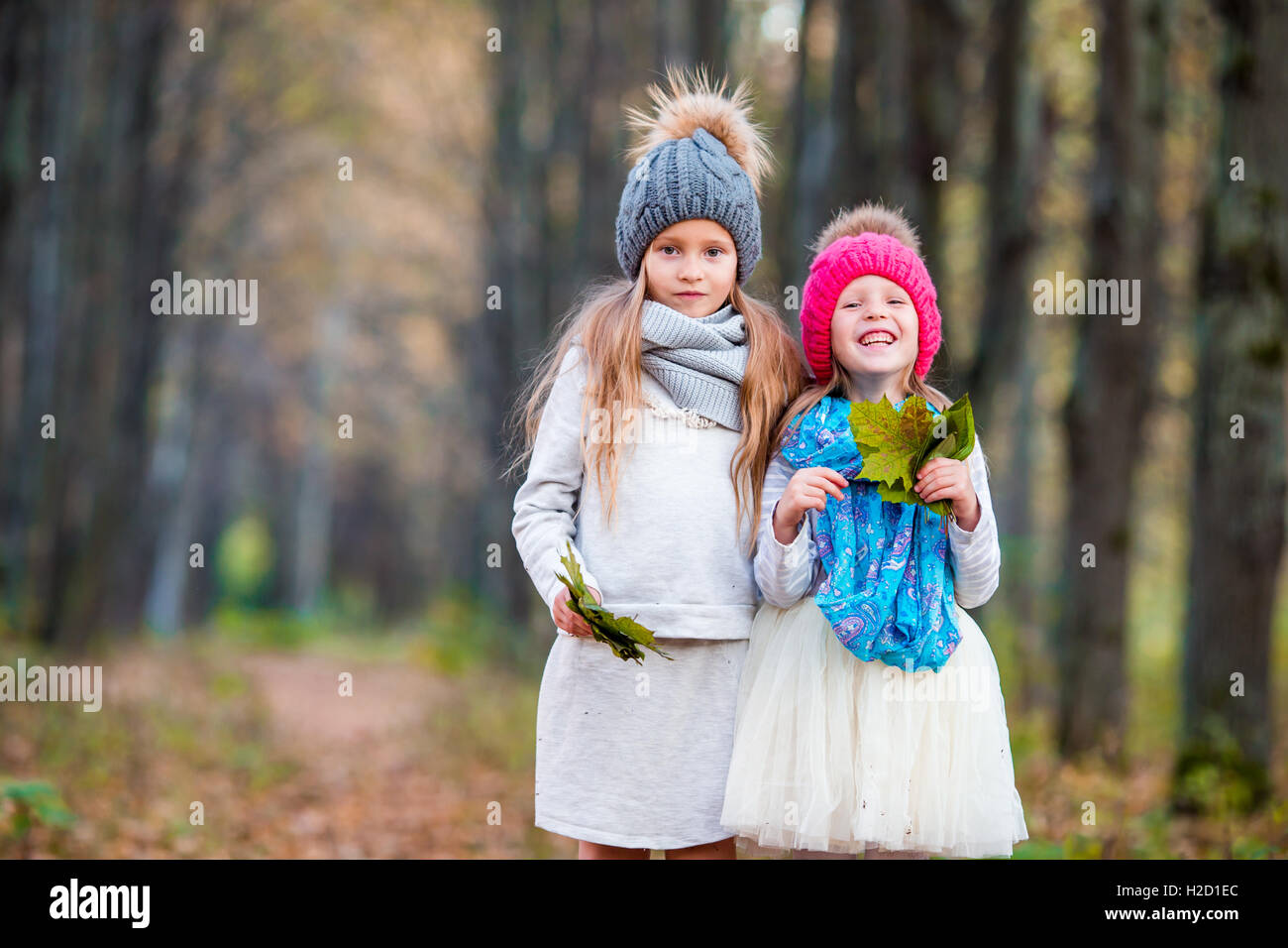 Two adorable girls in forest at warm sunny autumn day Stock Photo - Alamy