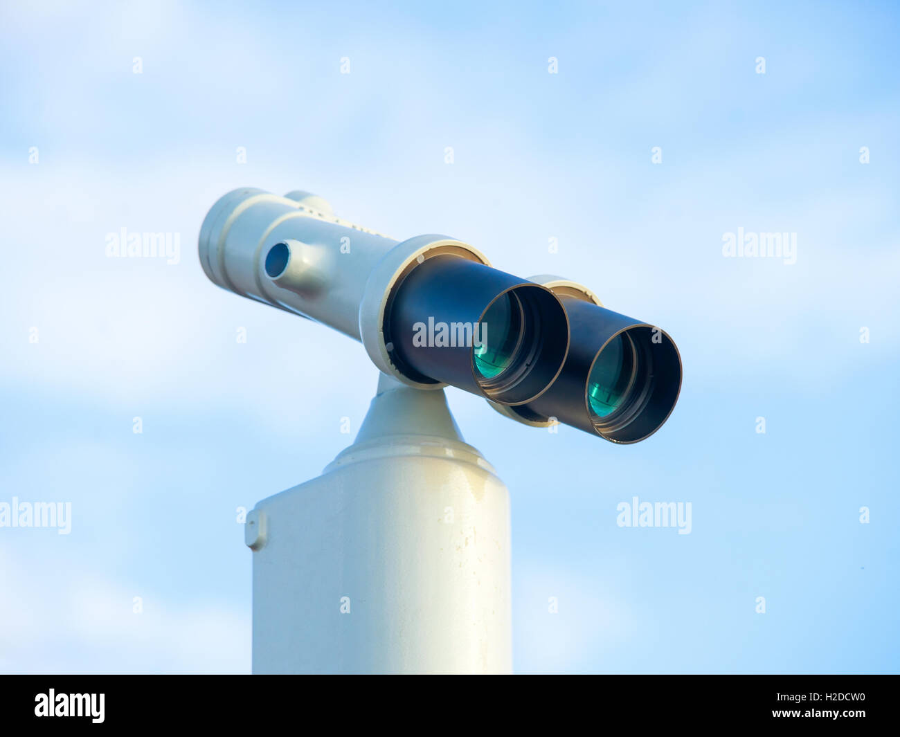 Stationary binocular against clear blue sky. Front view with reflection ...