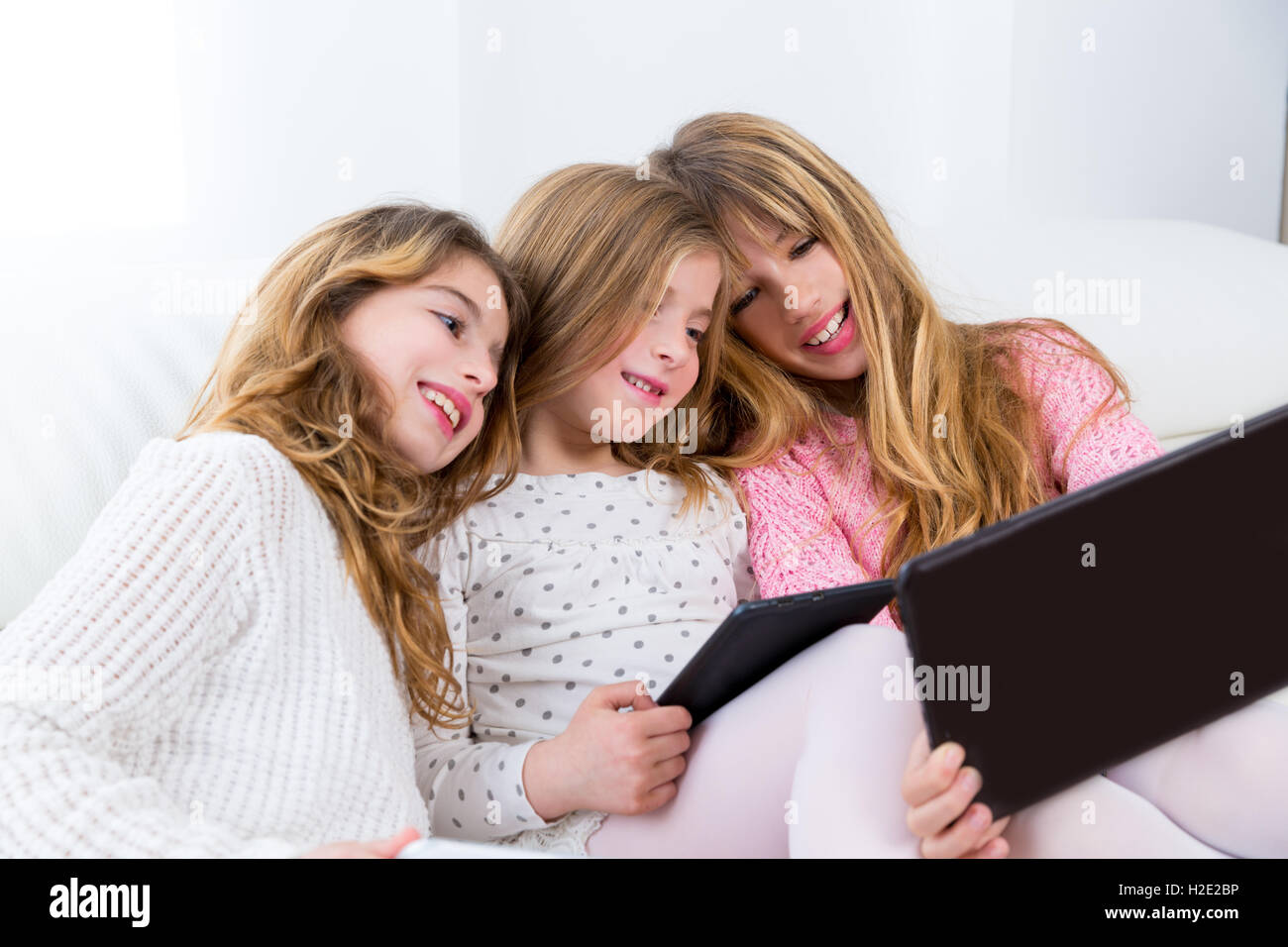 three kid sister friends girls group playing together with table Stock ...