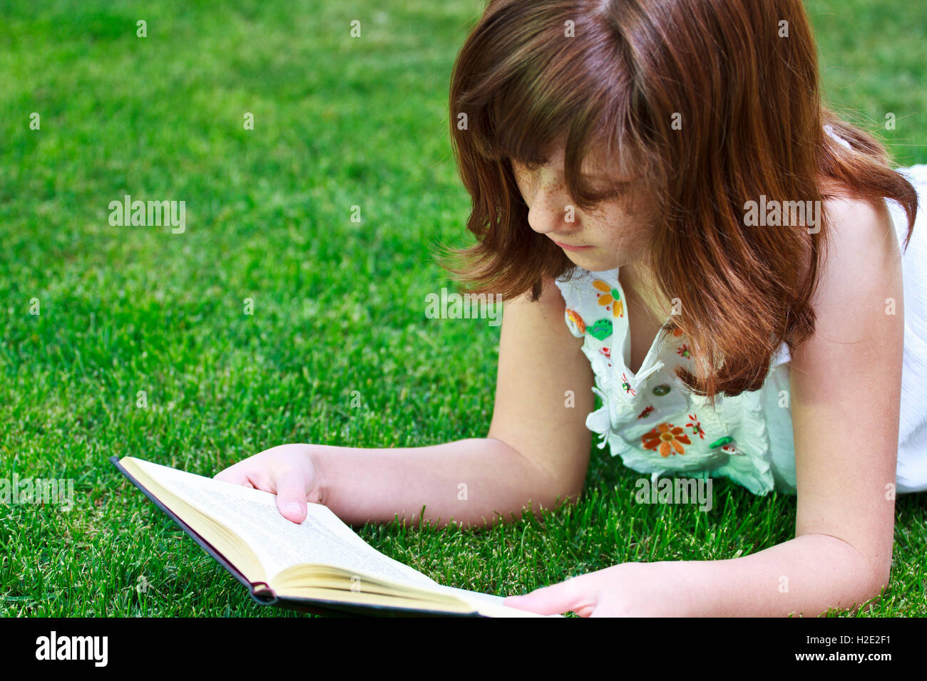 Read.Young beautiful girl reading a book outdoor Stock Photo - Alamy