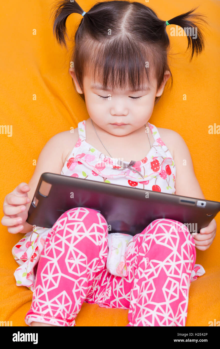 Little girl using a digital tablet Stock Photo - Alamy