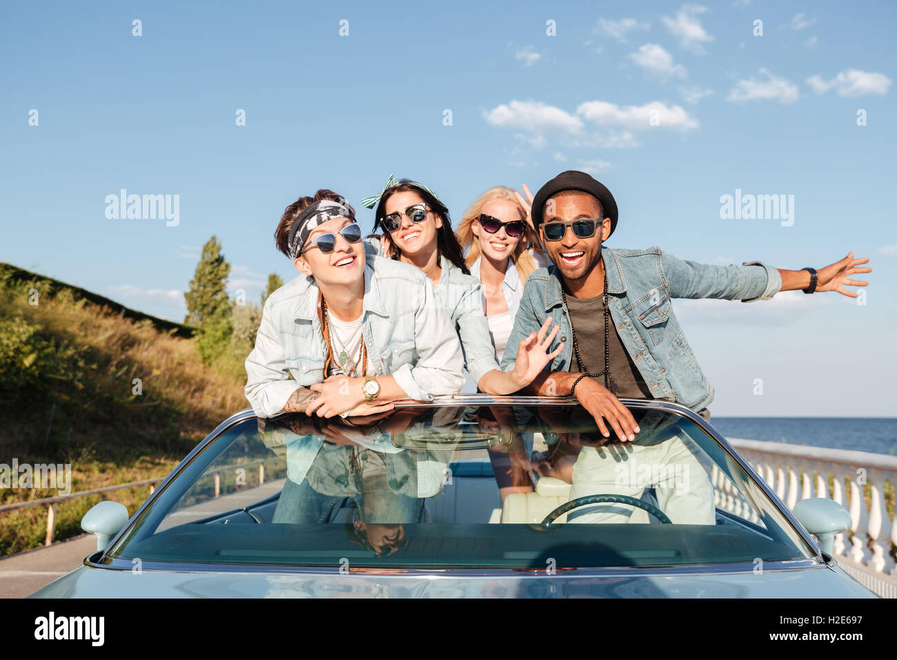 Joyful young friends having fun in cabriolet Stock Photo - Alamy