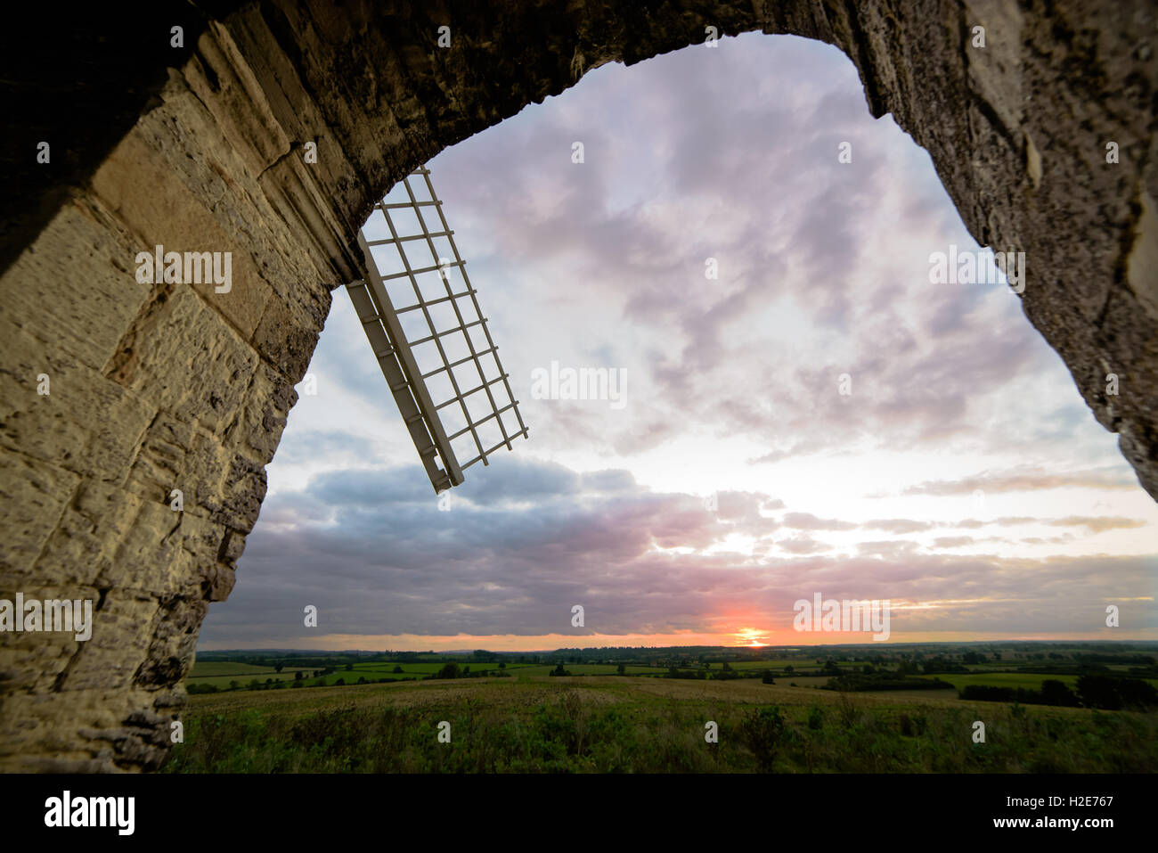 View of the sunset through the arch of a windmill in Warwickshire UK ...