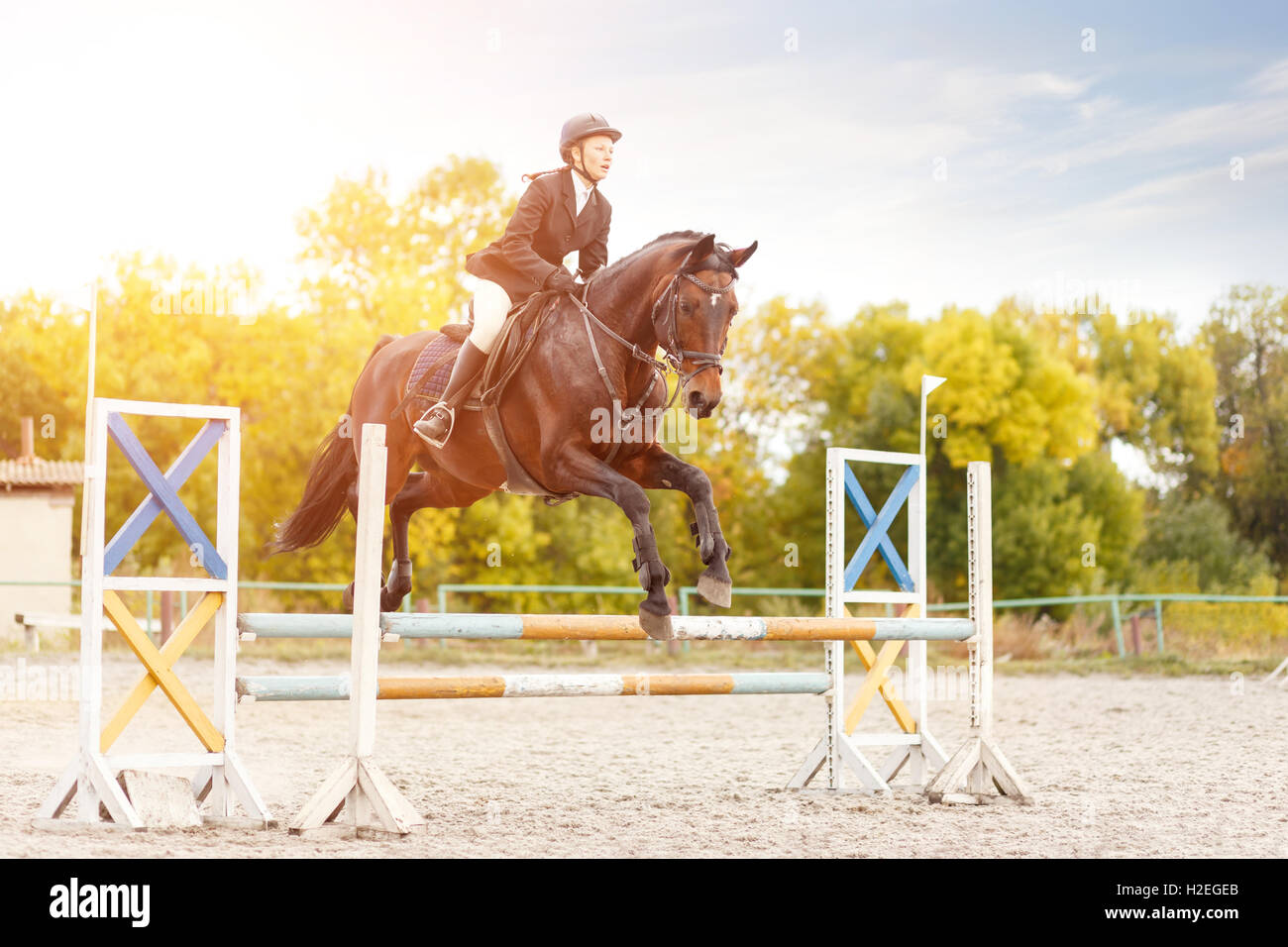 Young rider girl performing jump at horse show jumping competition ...