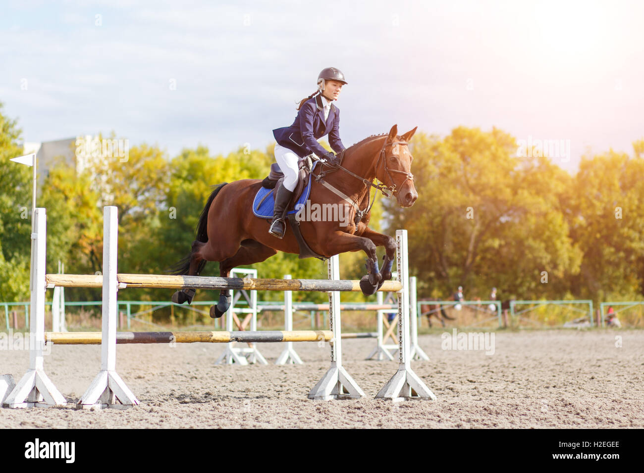 Young rider girl performing jump at horse show jumping competition ...