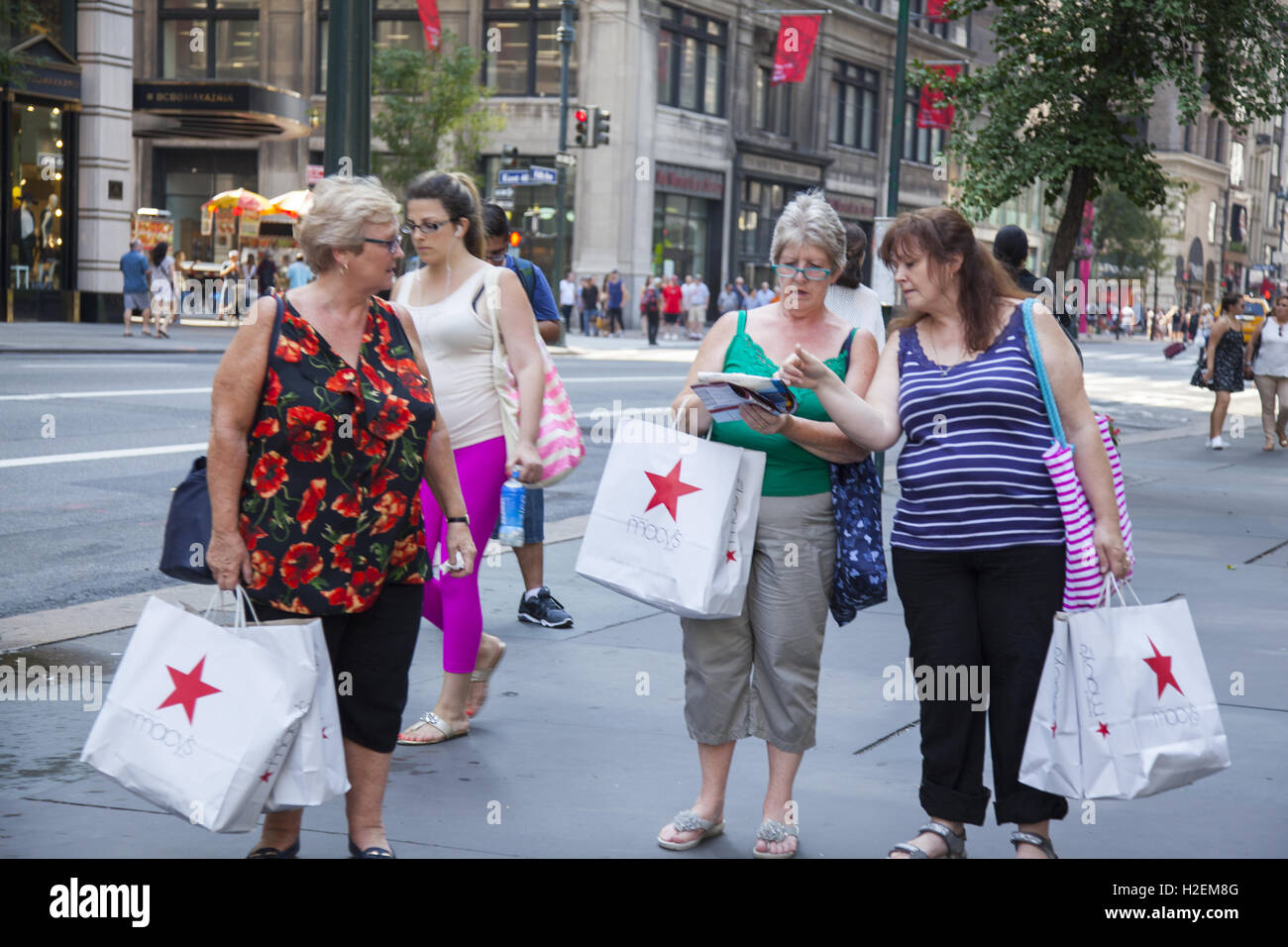 Three women all with Macy's shopping bags on 5th Avenue in midtown ...