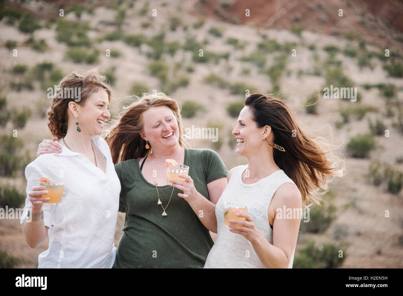 Three women standing in a desert landscape Stock Photo - Alamy