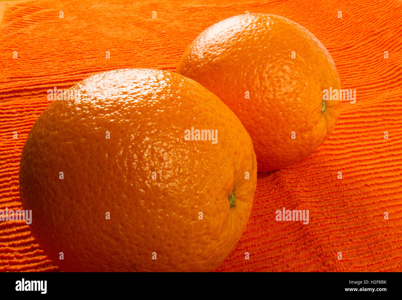 Two Orange on the textile orange background Stock Photo - Alamy