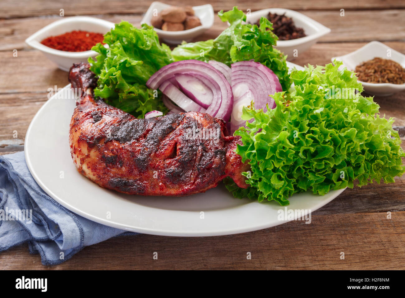 Indian tandoori leg chicken with spices and vegetables Stock Photo - Alamy
