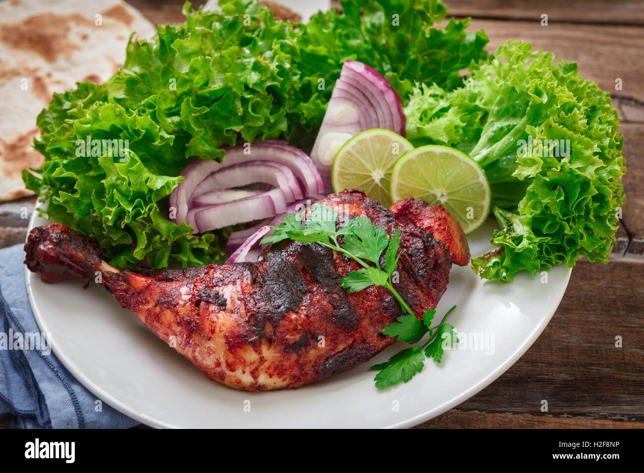 Indian tandoori leg chicken with spices and vegetables Stock Photo - Alamy