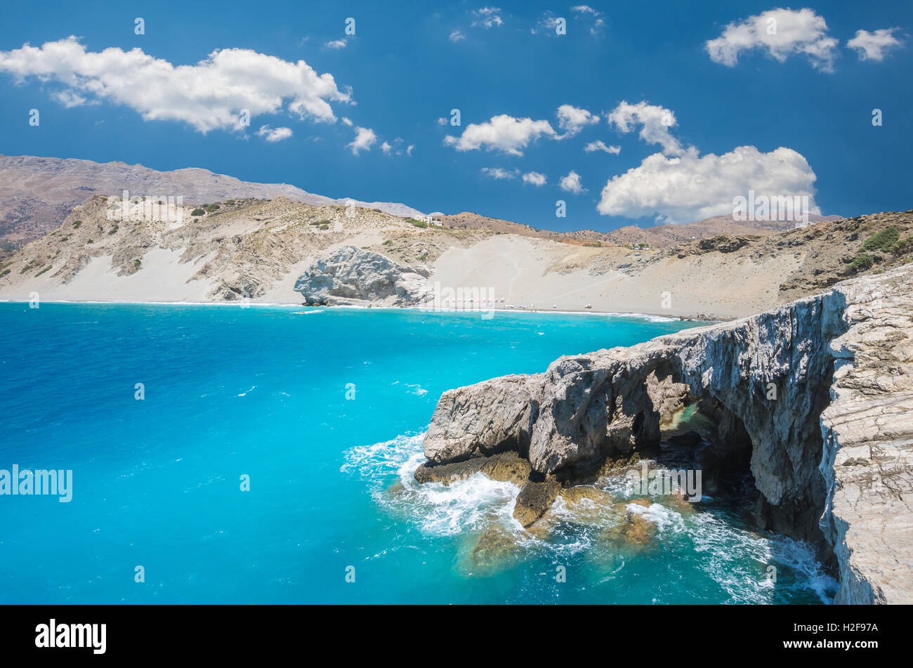 Agios Pavlos Beach in Crete island, Greece. Tourists relax and bath in crystal clear water of St ...