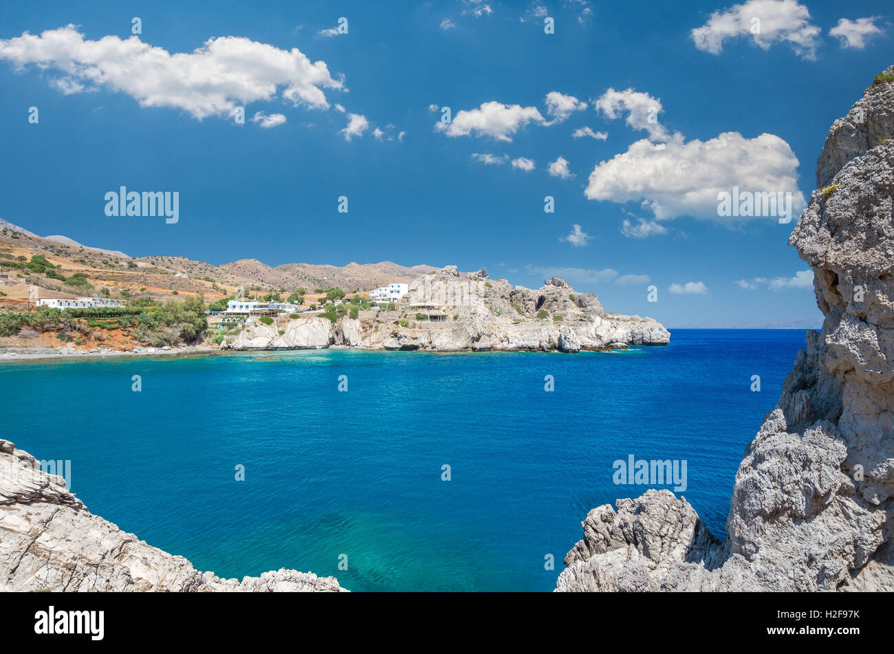 Agios Pavlos Beach in Crete island, Greece. Tourists relax and bath in crystal clear water of St ...