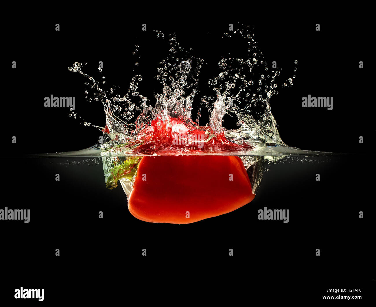 Red bell pepper falling in water with splash on black background Stock ...