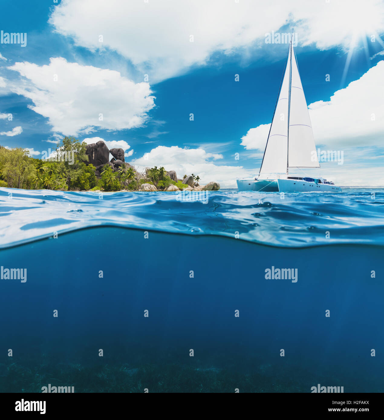 Catamaran boat sailing next to tropical island in Seychelles Stock ...