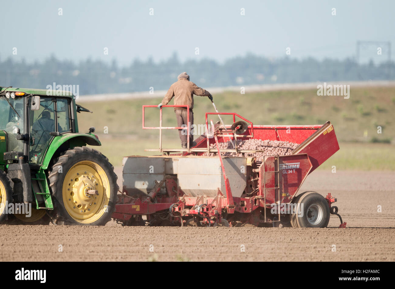 Farmers planting potatoes with machinery Stock Photo - Alamy