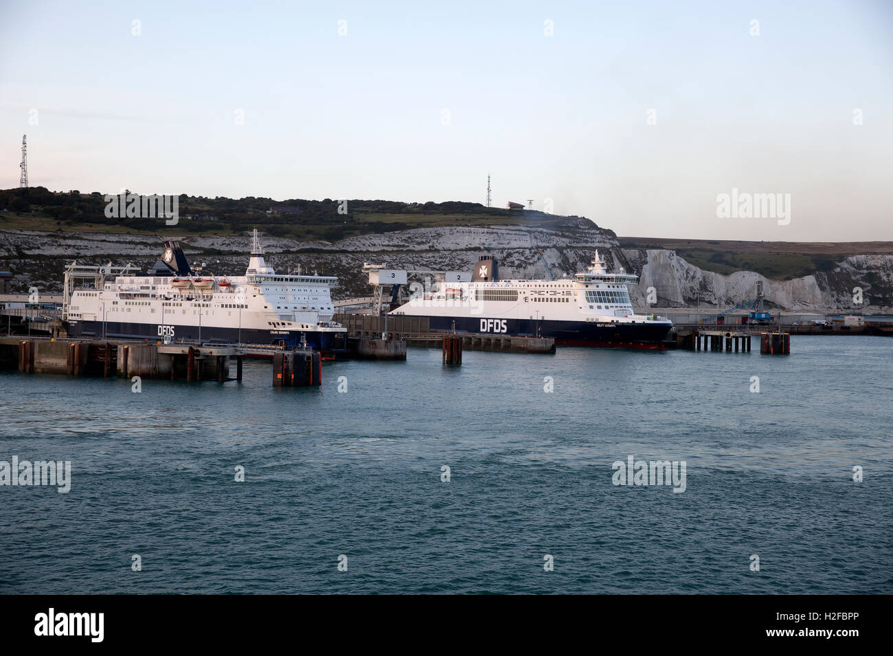 A view of the white cliffs of Dover in the UK with two ships docked in ...
