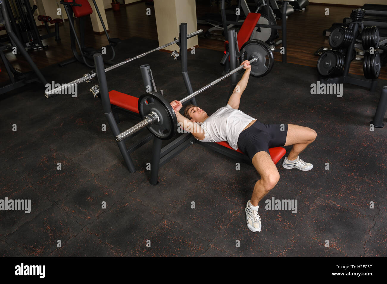 young man doing bench press workout in gym Stock Photo - Alamy