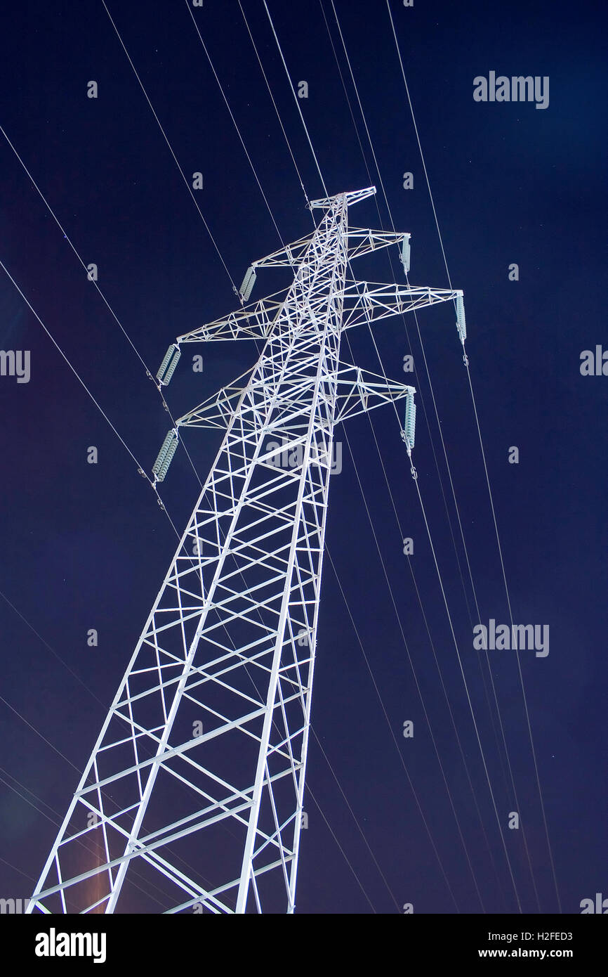 Large electricity pylon by night with dark starry sky as a background ...